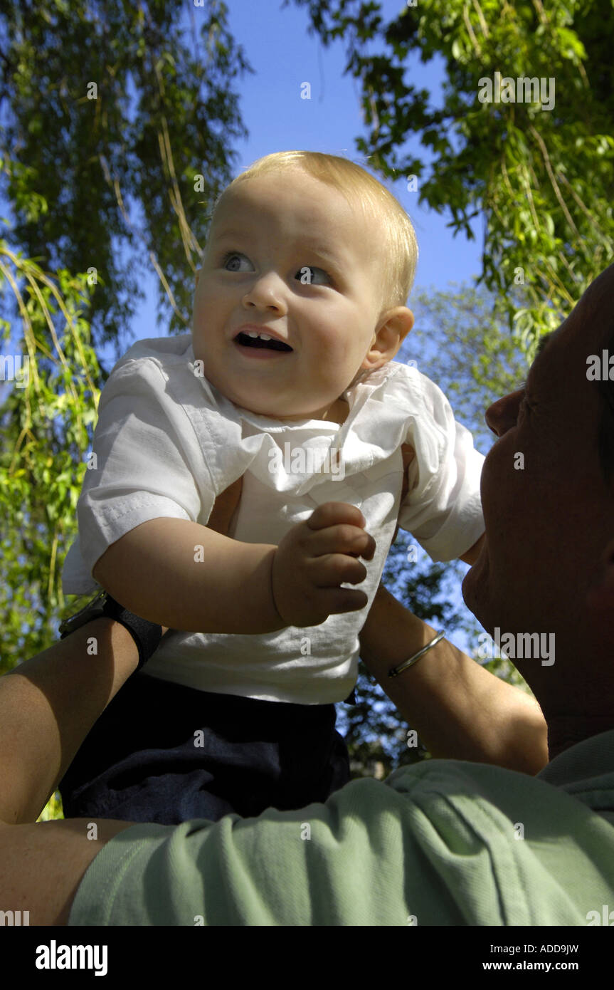 father holding baby boy aloft in his arms Stock Photo - Alamy