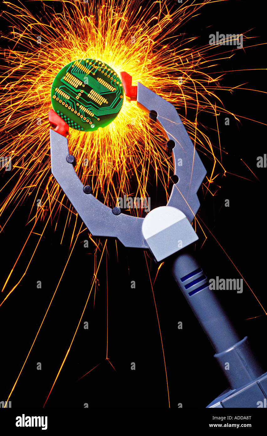 Robot arm holding round circuit board with sparks Stock Photo - Alamy