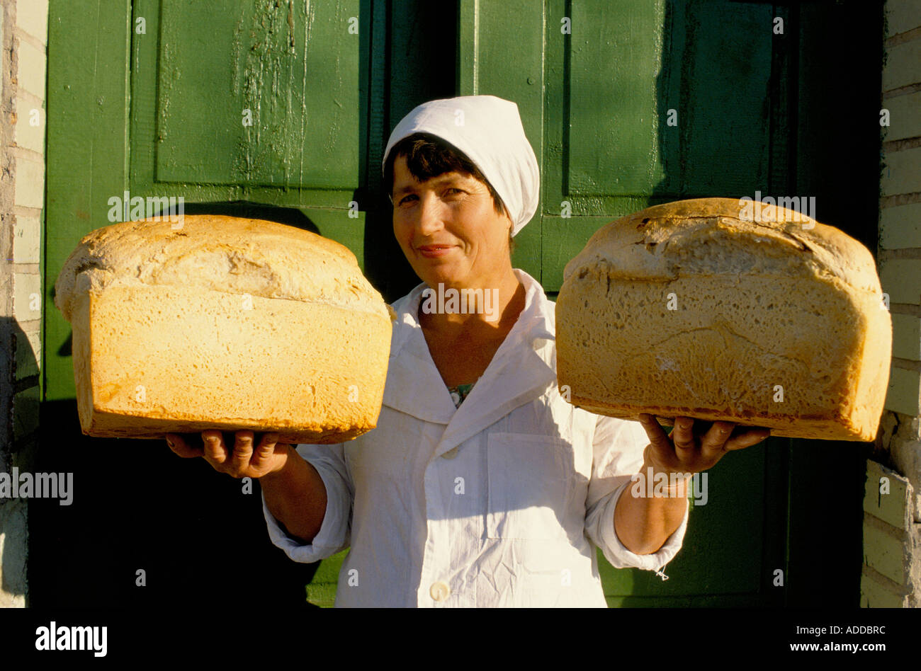 Ukraine', 1989. a woman bakery worker with outsize loaves of bread at ...