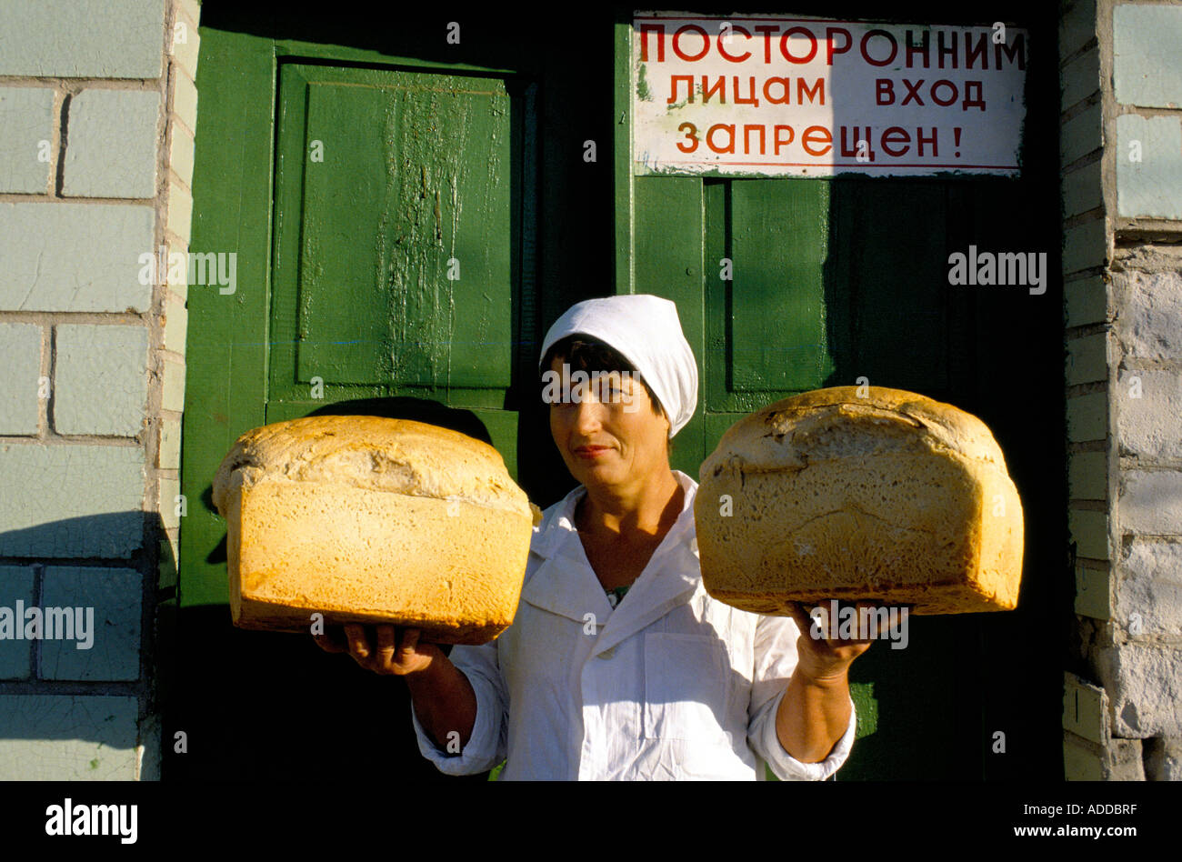 Ukraine', 1989. a woman bakery worker with outsize loaves of bread at ...