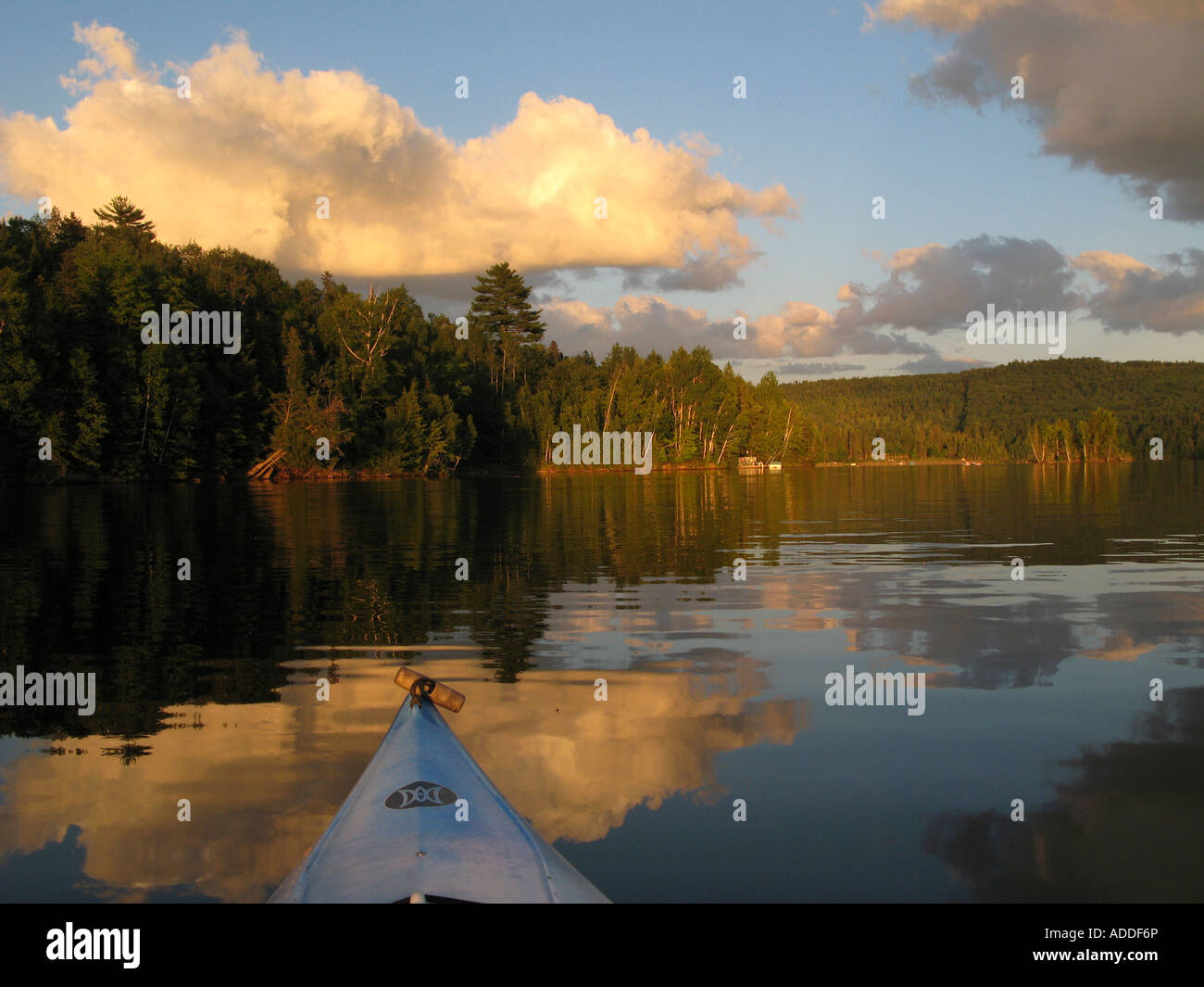 Kayaking on Kelly Creek Lake at sunset with magenta clouds during a ...