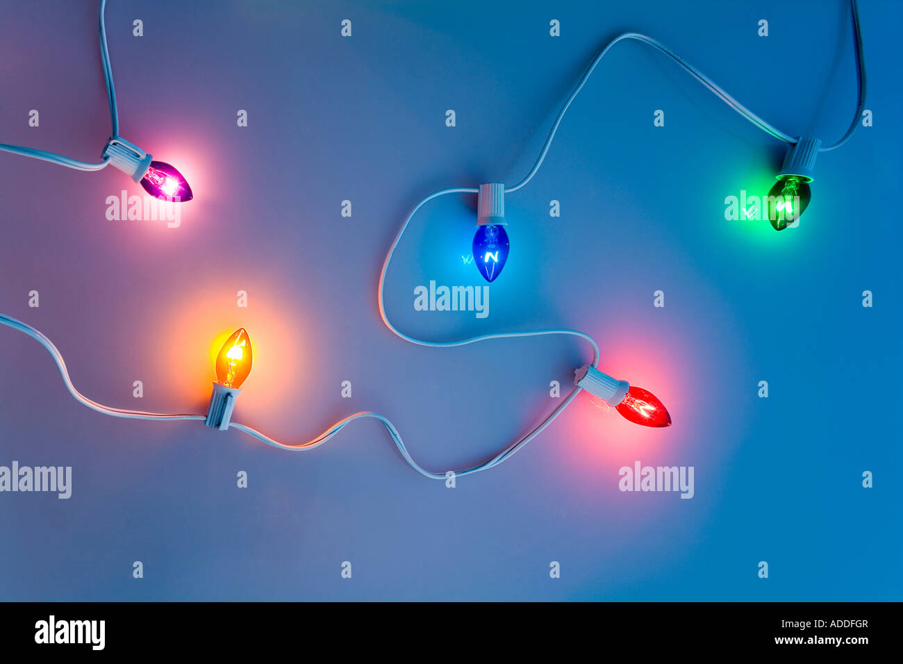 One black strand of multi colored Christmas tree lights waving through ...