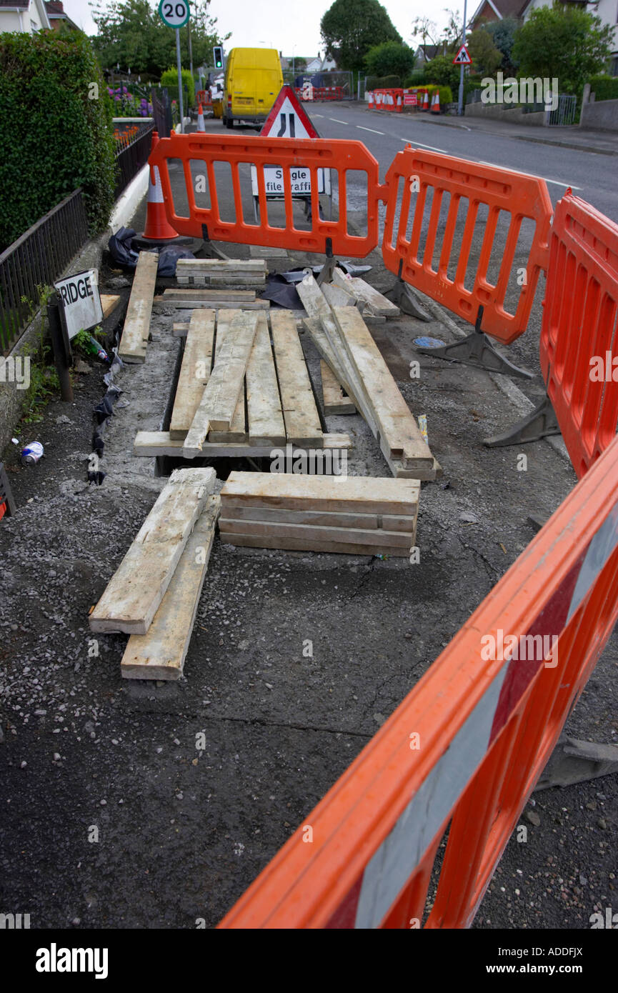 wooden planks covering newly created manhole cable access with plastic ...