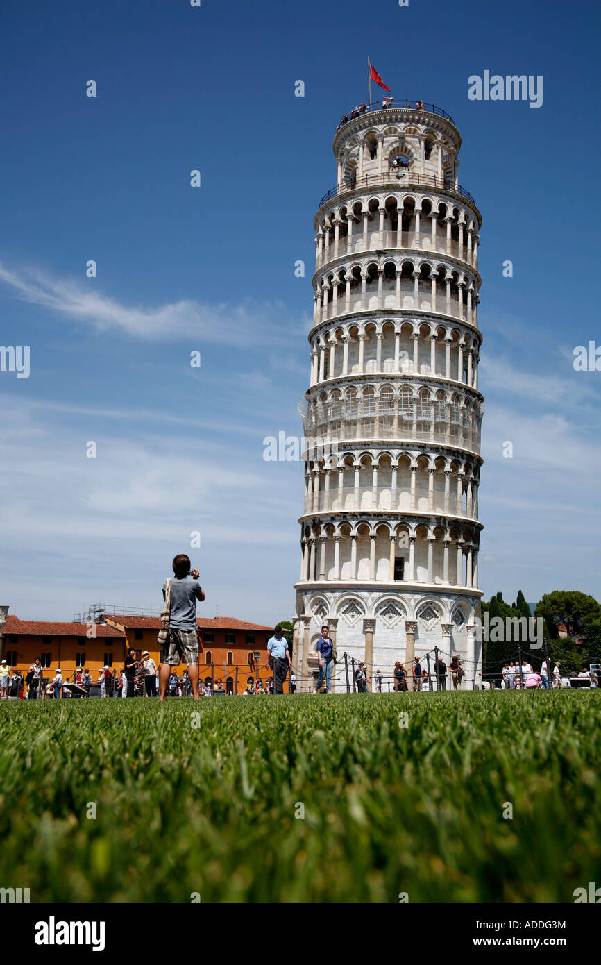 Tourist photographing the Leaning Tower of Pisa in the Piazza del Duomo ...