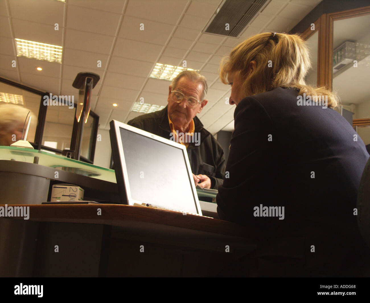 Female bank employee at desk with laptop computer Stock Photo - Alamy