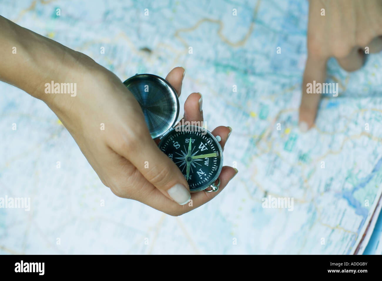 Woman pointing to map and holding compass, close-up Stock Photo - Alamy