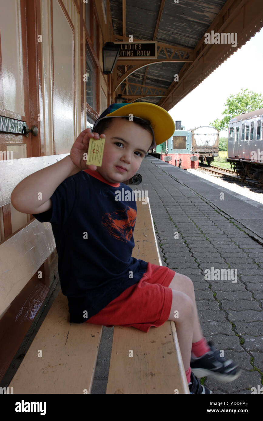 Small boy holding his tickets and waiting for the train to arrive Stock ...