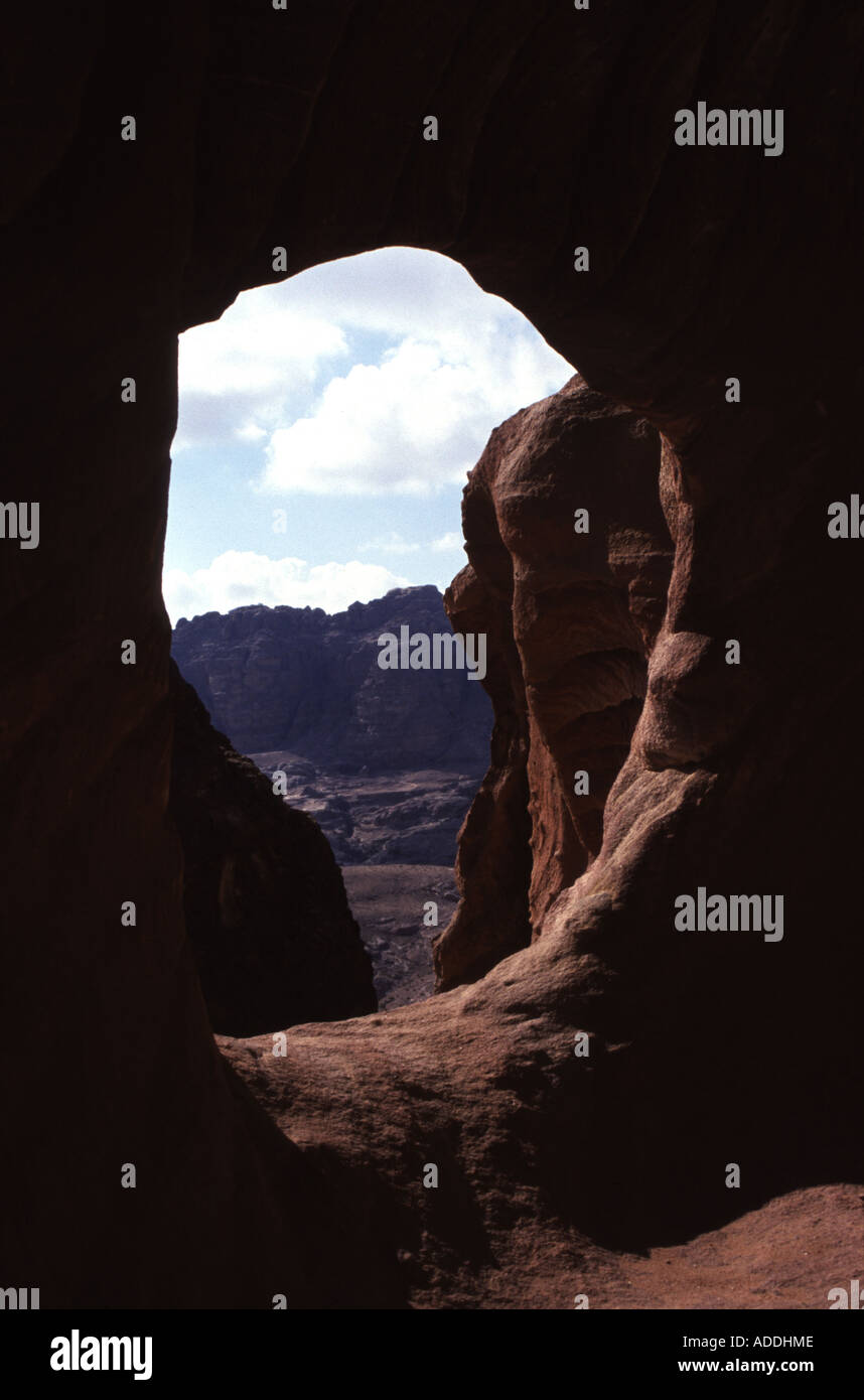 A rock hole in the red sandstone allows a glimpse of the petra ...