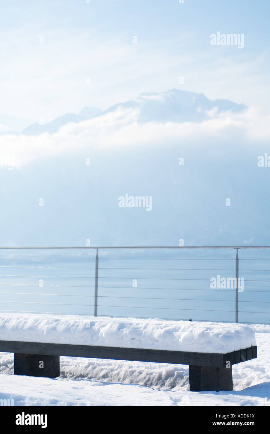 Snow-covered bench overlooking lake and mountains Stock Photo - Alamy