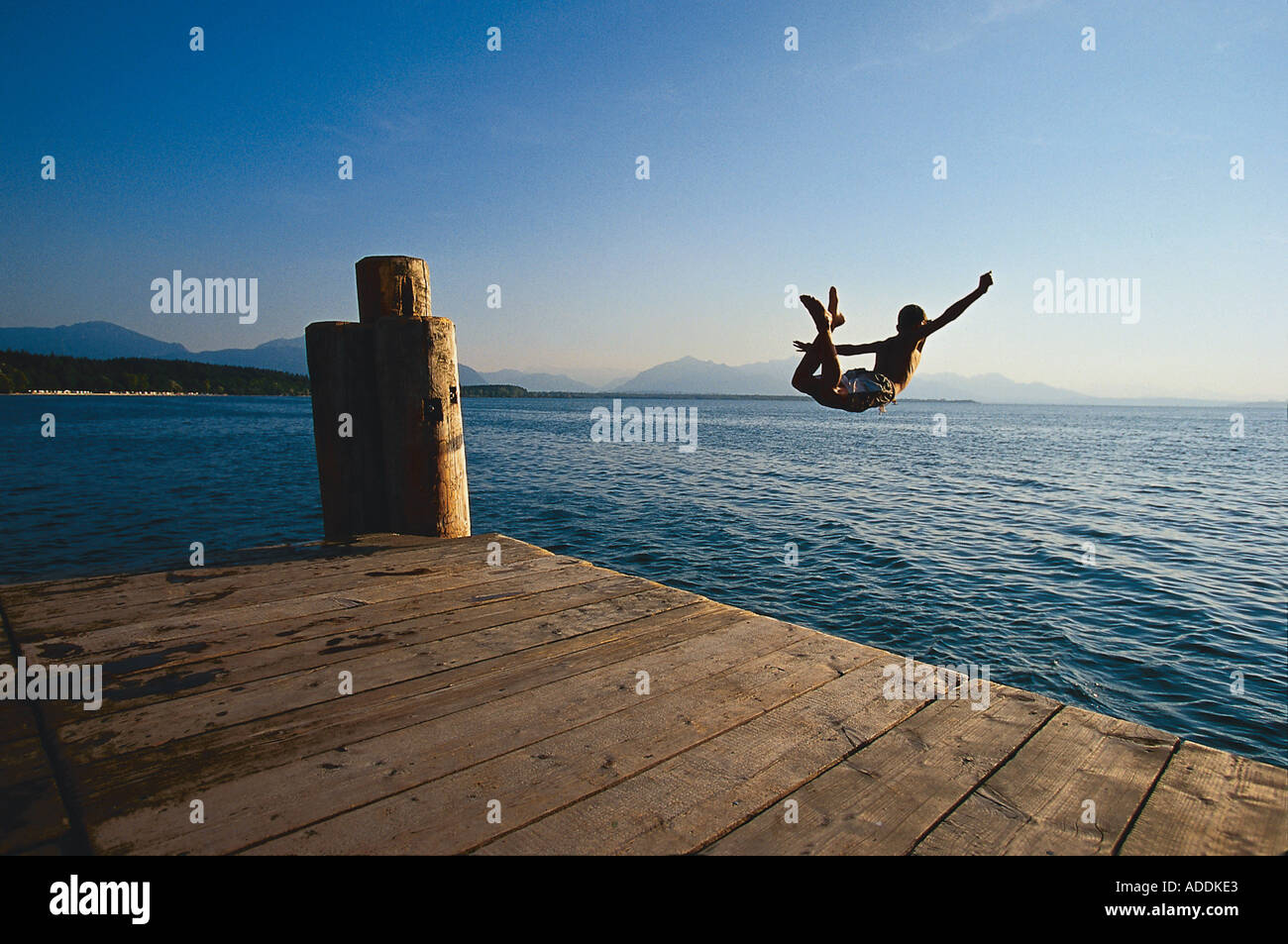 Man jumping from a jetty into the lake, Chieming, Chiemsee, Upper ...
