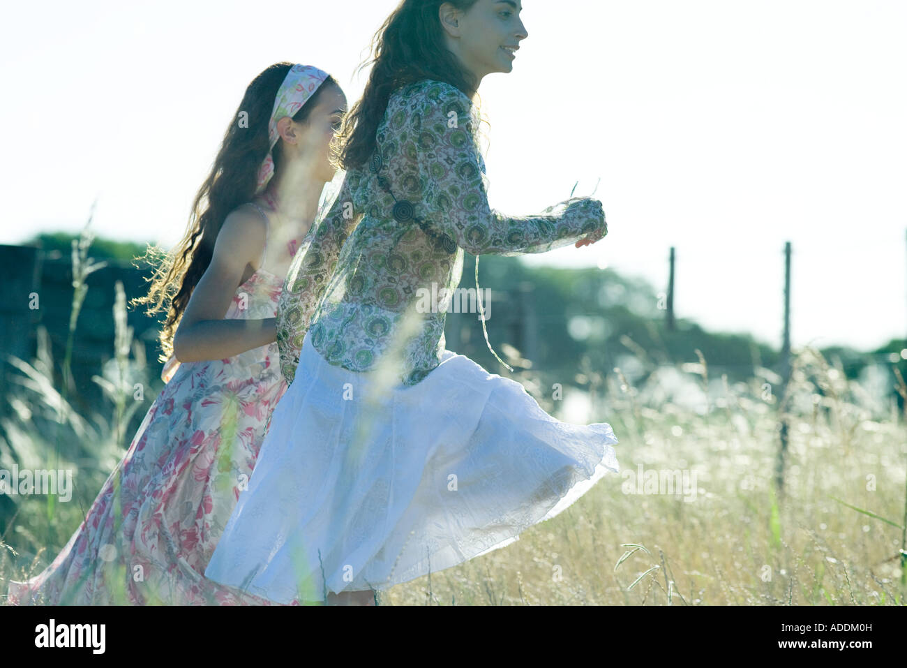 Young hippie women running in field Stock Photo - Alamy