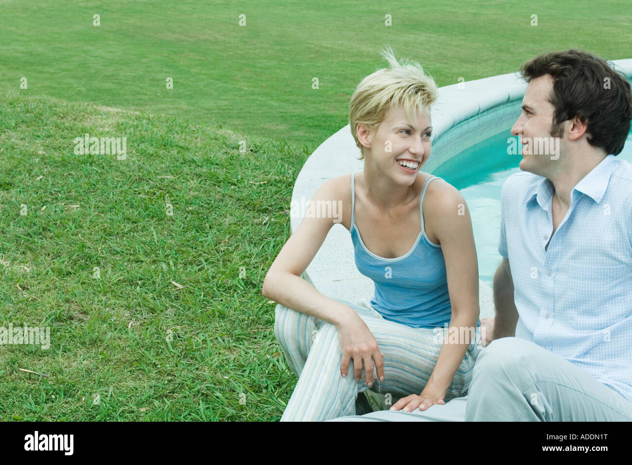 Two couples sitting by swimming pool hi-res stock photography and ...