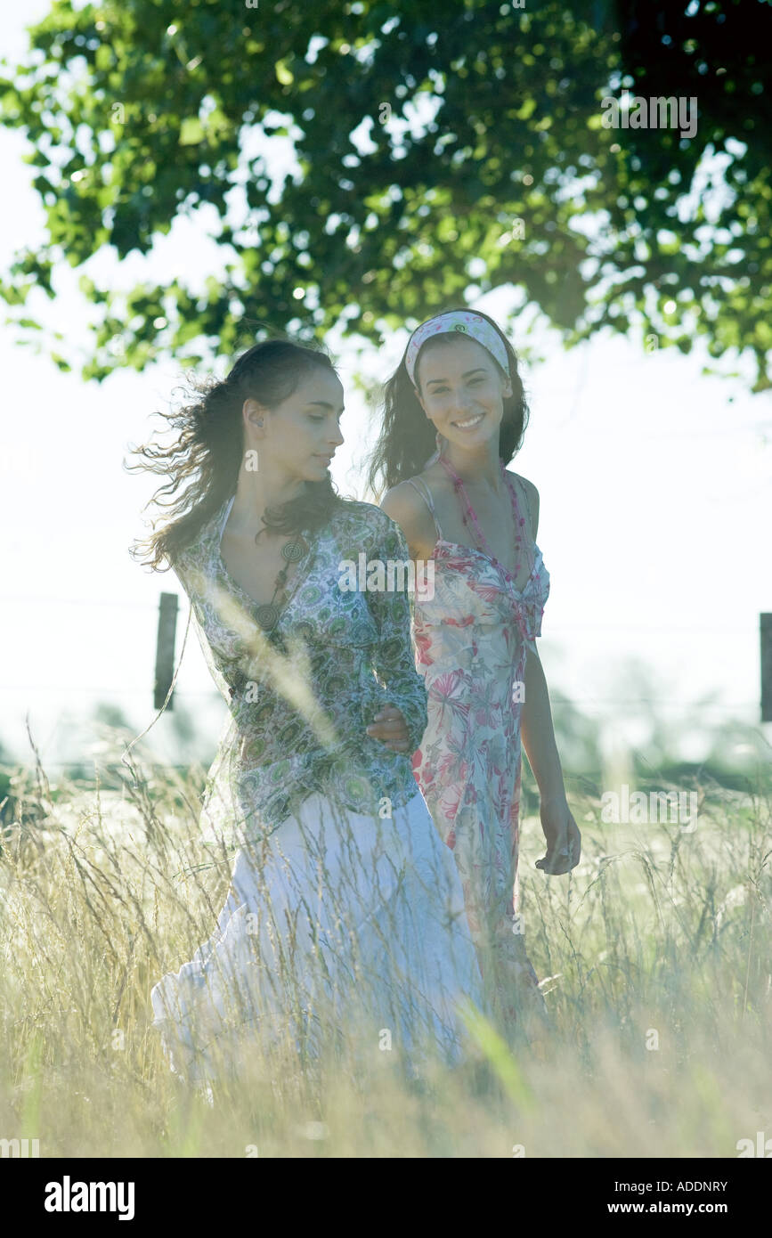 Young women walking through field Stock Photo - Alamy