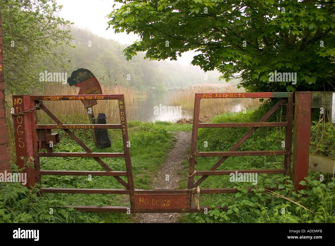 Entrance gate to a fishing lake Cheshire with signs and warnings Stock ...