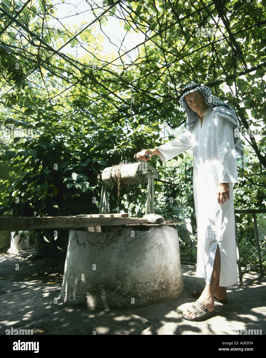 Man in white Arabic clothes at the well Stock Photo - Alamy
