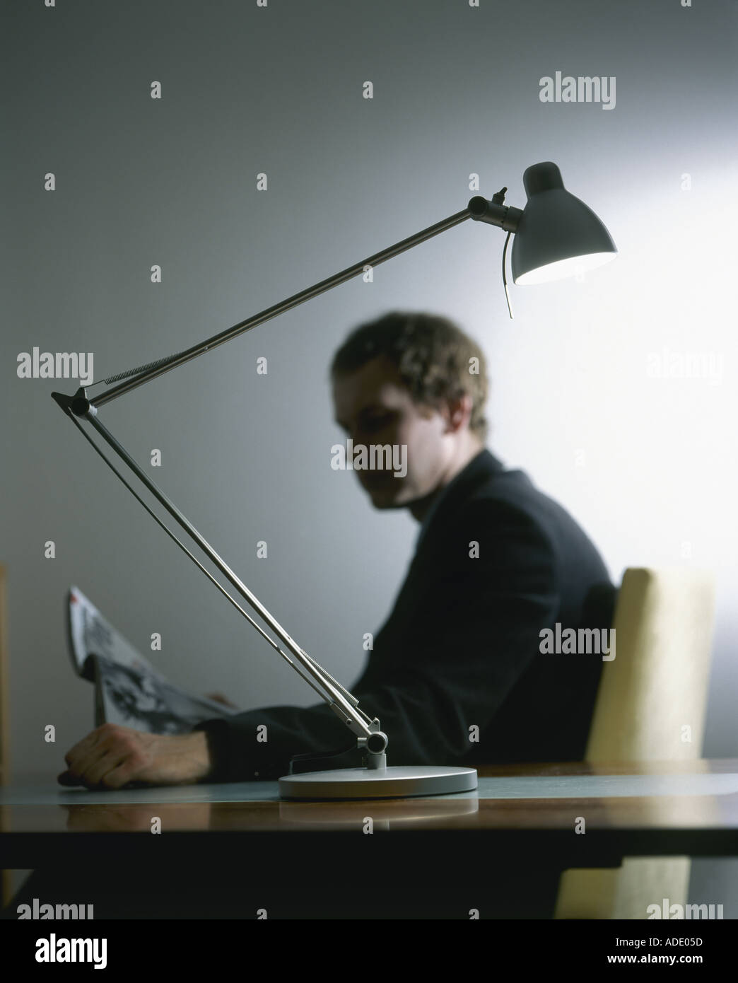 Man at the table reading magazine Stock Photo - Alamy