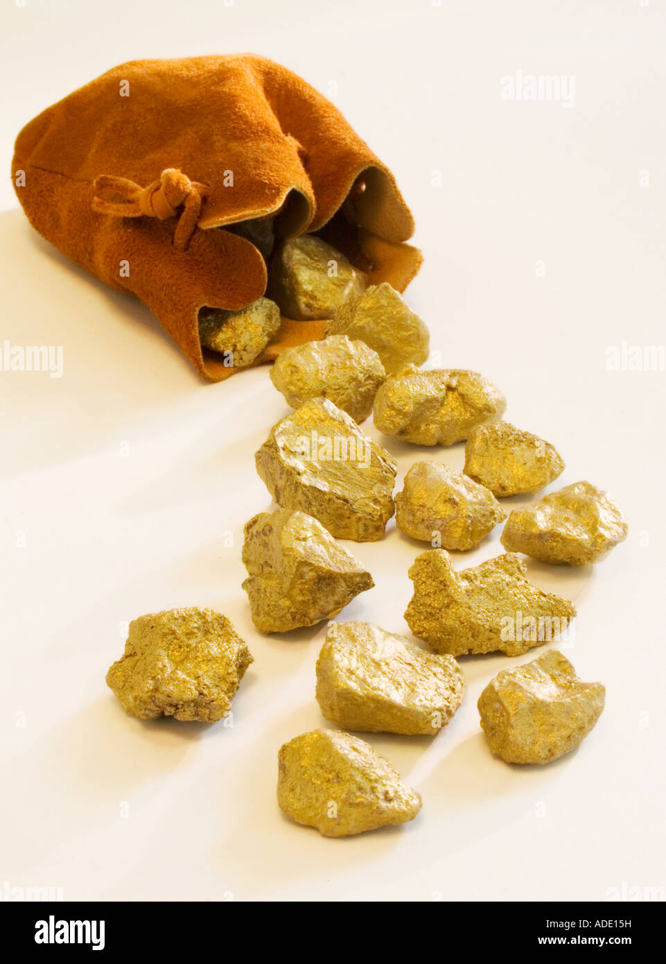 Gold nuggets spilling out of a leather pouch Stock Photo - Alamy