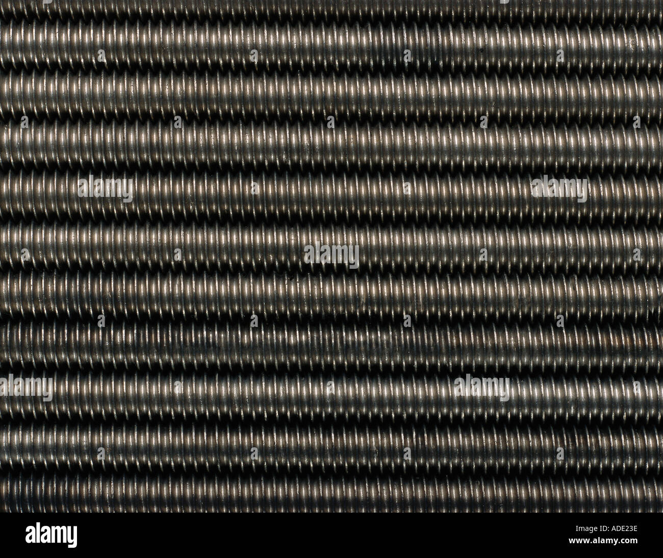 A close up or background of gray shiny industrial grooved metal pipes ...