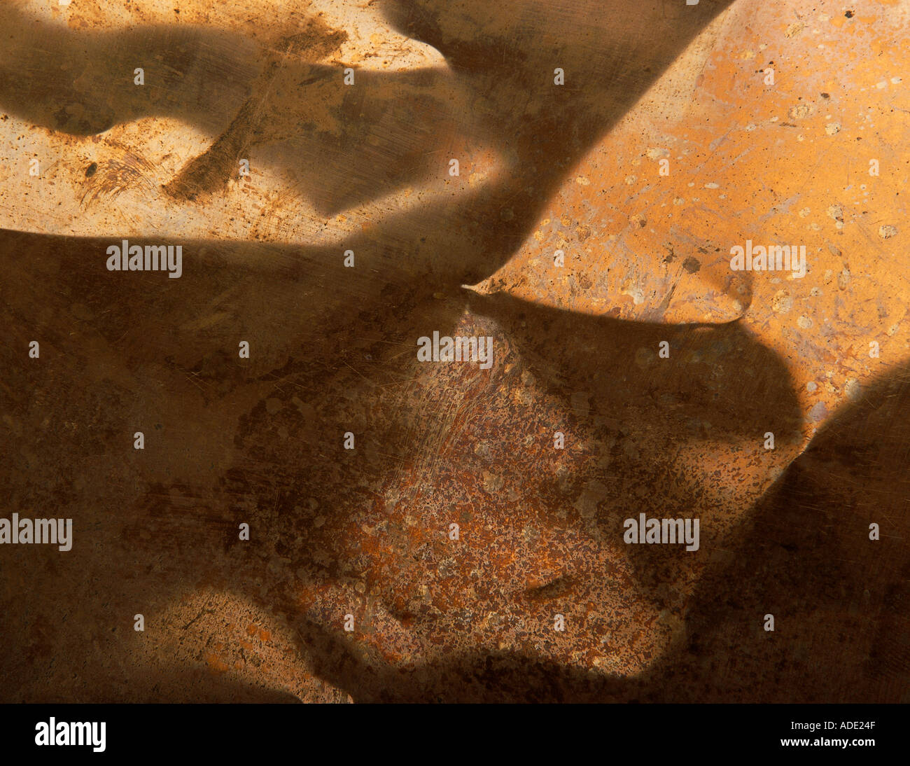 A close up of a brownish orange piece of dented and scratched copper ...