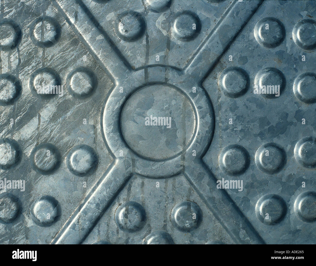 A close up of a shiny piece of galvanized steel with a raised surface ...