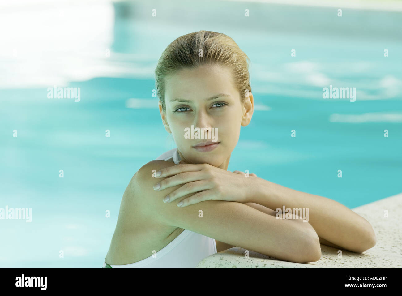 Woman wearing halter bathing suit, head and shoulders, leaning on edge ...