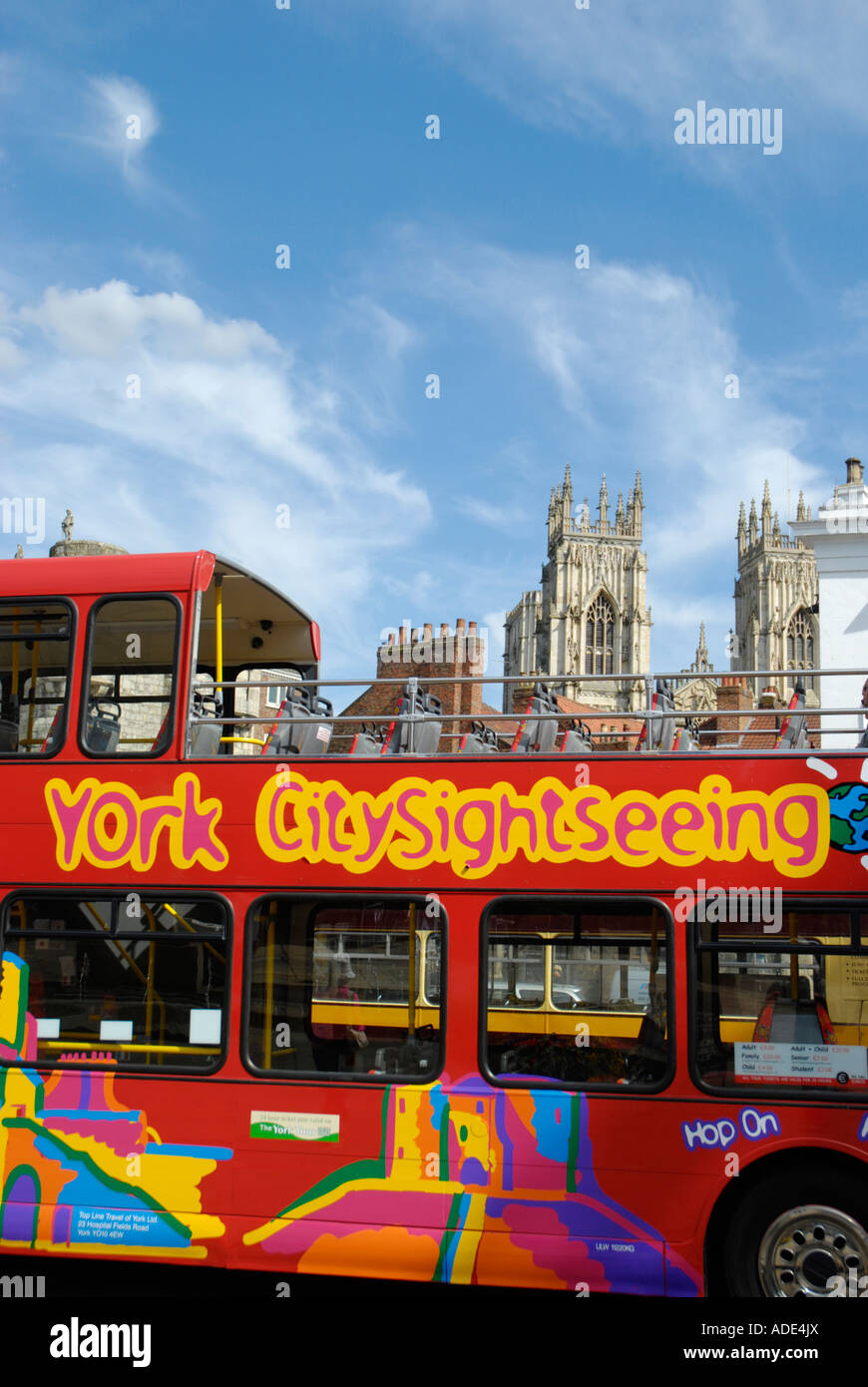 Red York open deck sightseeing bus against towers of York Minster and ...