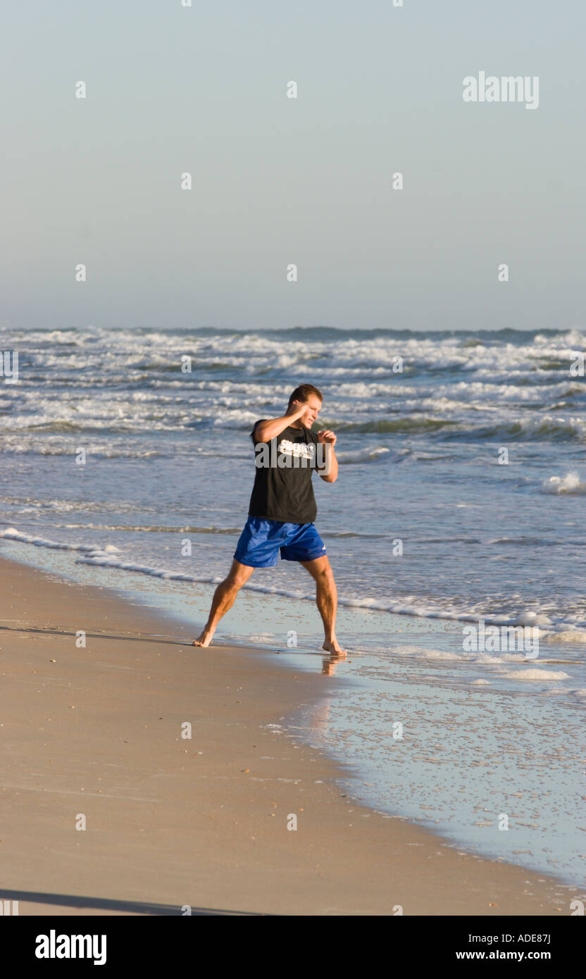 Man shadow boxing on beach while in training Stock Photo - Alamy
