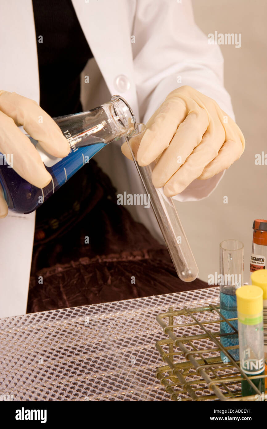 Scientist mixes chemicals while performing an experiment Stock Photo ...