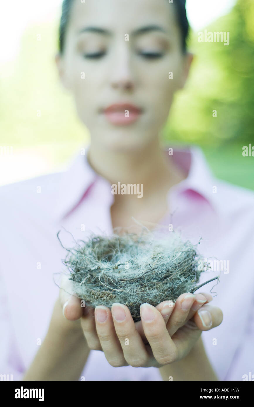 Woman holding bird's nest in palm of hand Stock Photo - Alamy