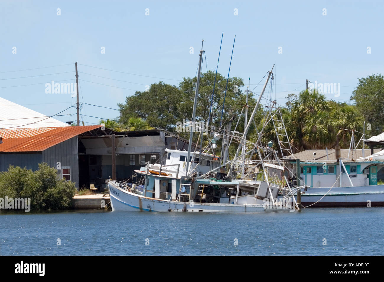 A Large White Shrimp Boat Sits on the Bottom After Sinking at the Dock ...