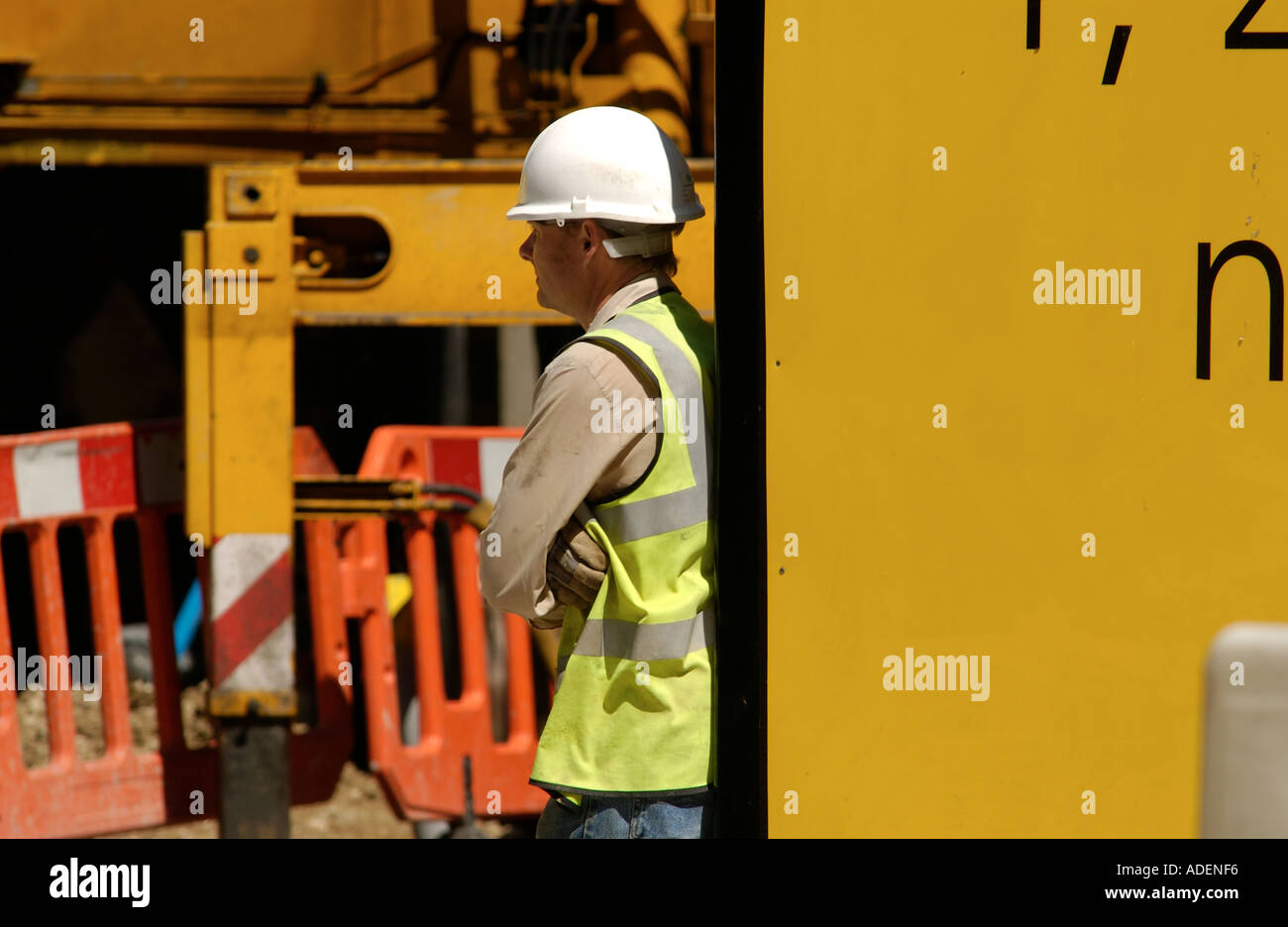 Workman leaning against a wall Stock Photo - Alamy