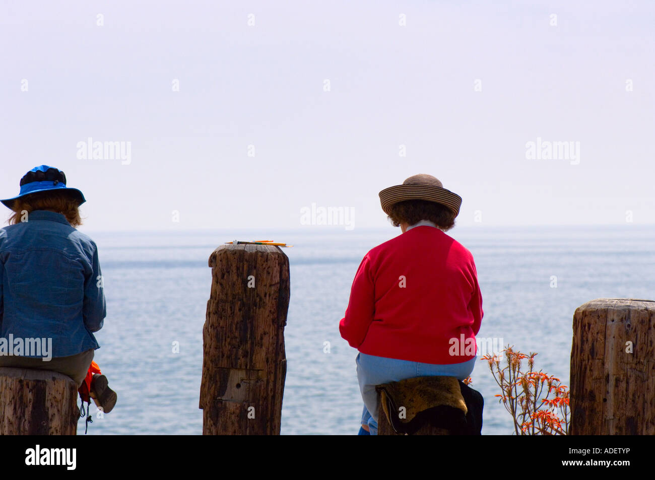 Two ladies drawing by the ocean Stock Photo - Alamy