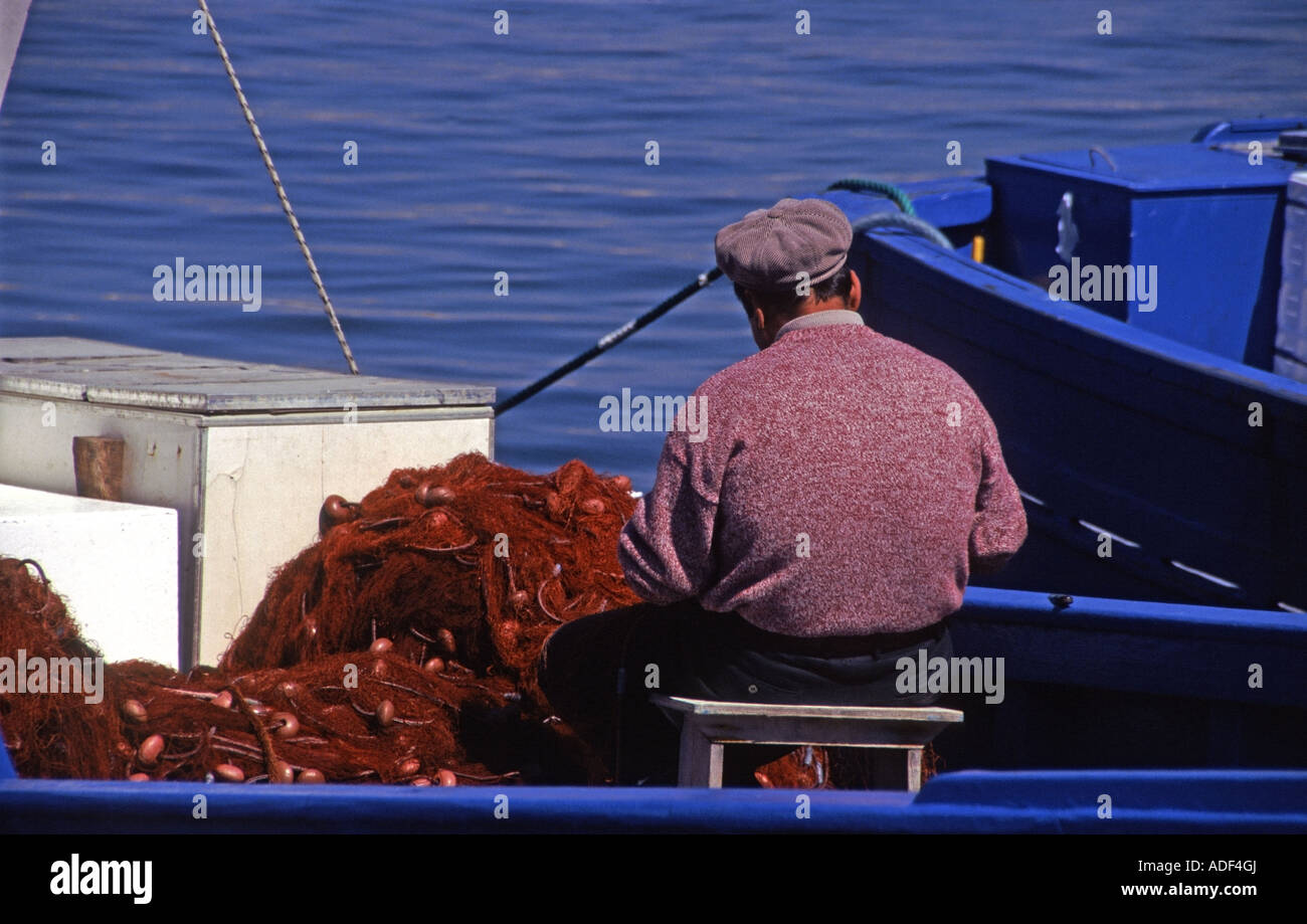 Typical mediterranean fisherman mending nets hi-res stock photography ...