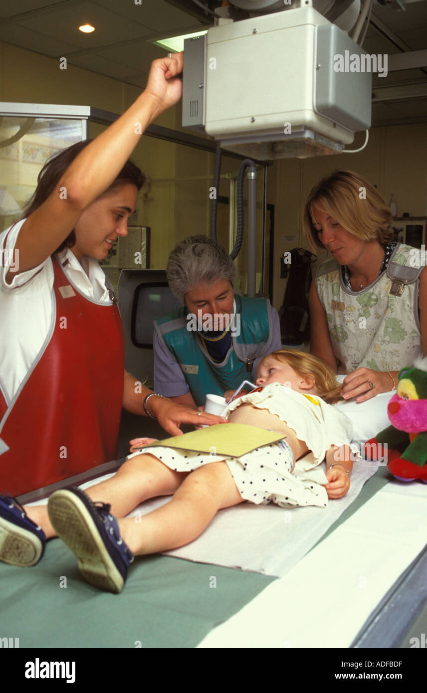 Young child being x rayed in hospital with mother standing behind for ...