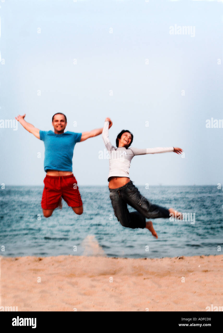 couple jumping on the beach Stock Photo - Alamy