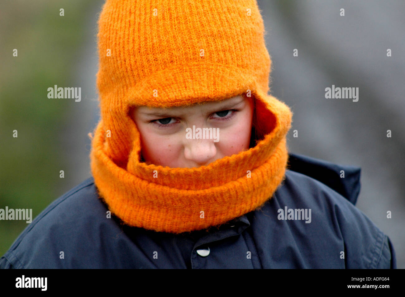 child in orange woolly hat looking cross or angry or in a mood Stock ...