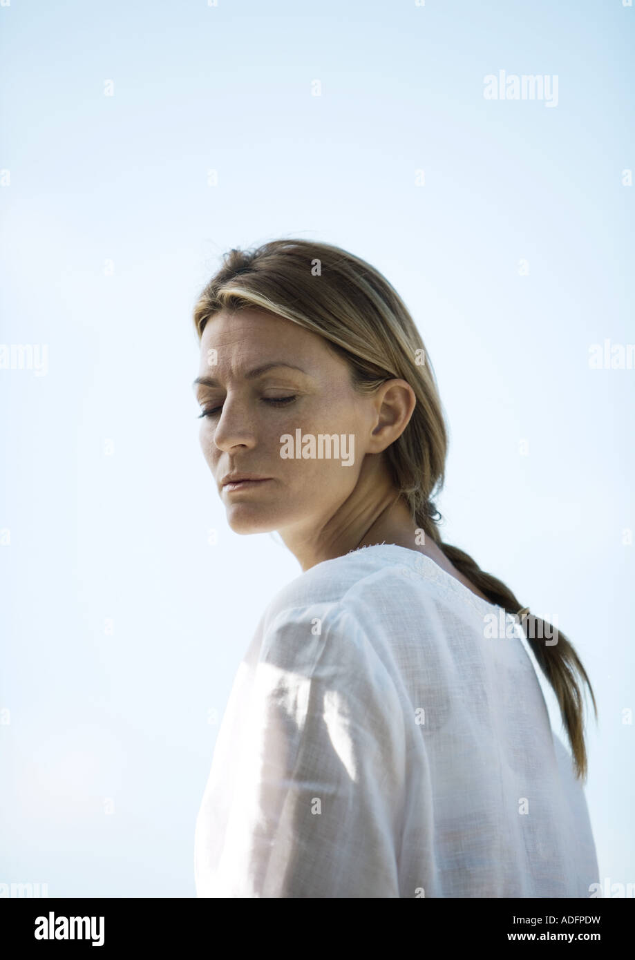 Woman turning head, eyes half-closed, low angle view Stock Photo - Alamy