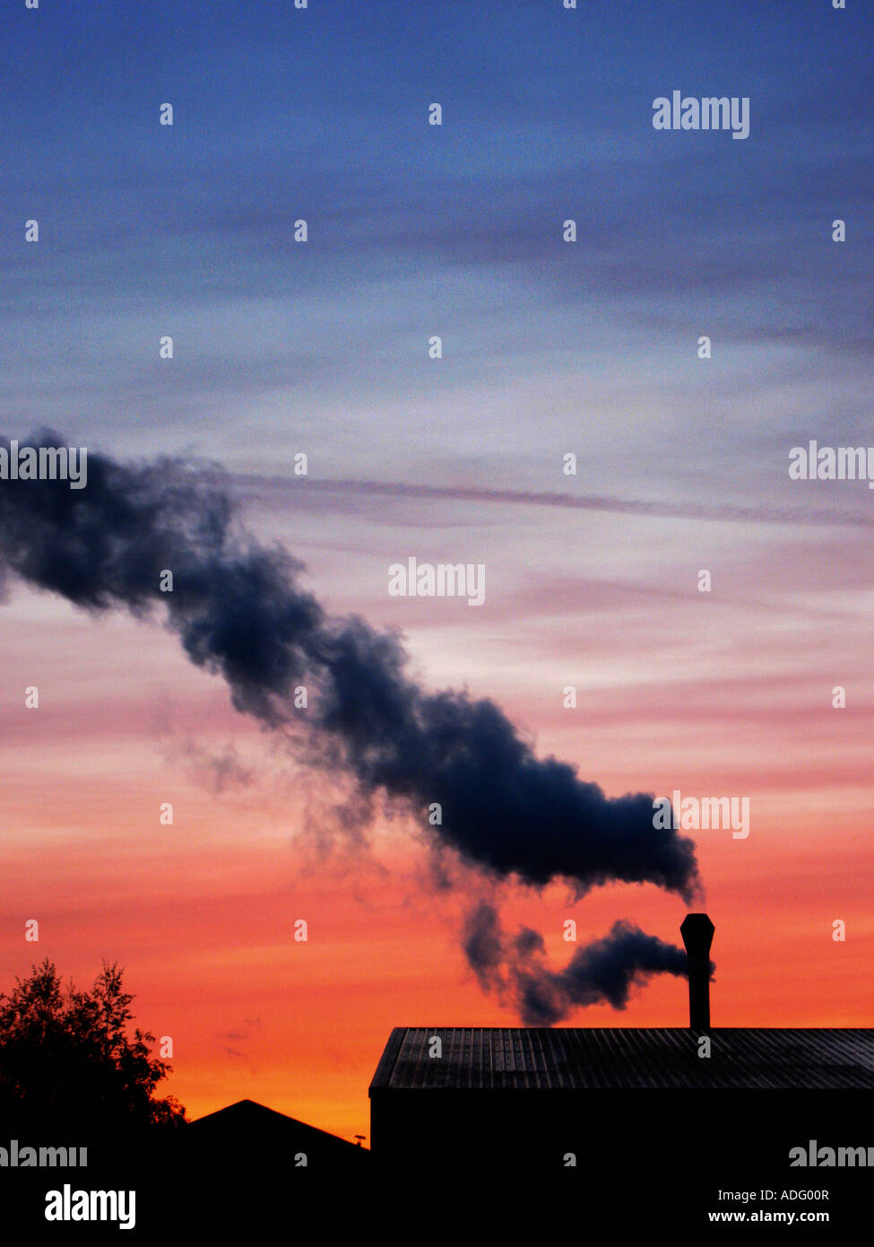Factory chimney releasing steam at dusk Stock Photo - Alamy