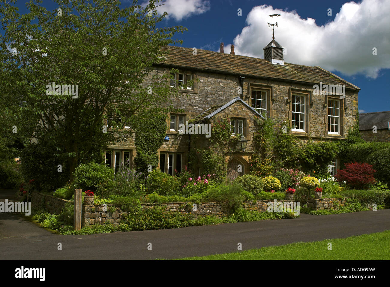 The old stone-built Court House and its garden in summer sunshine in ...