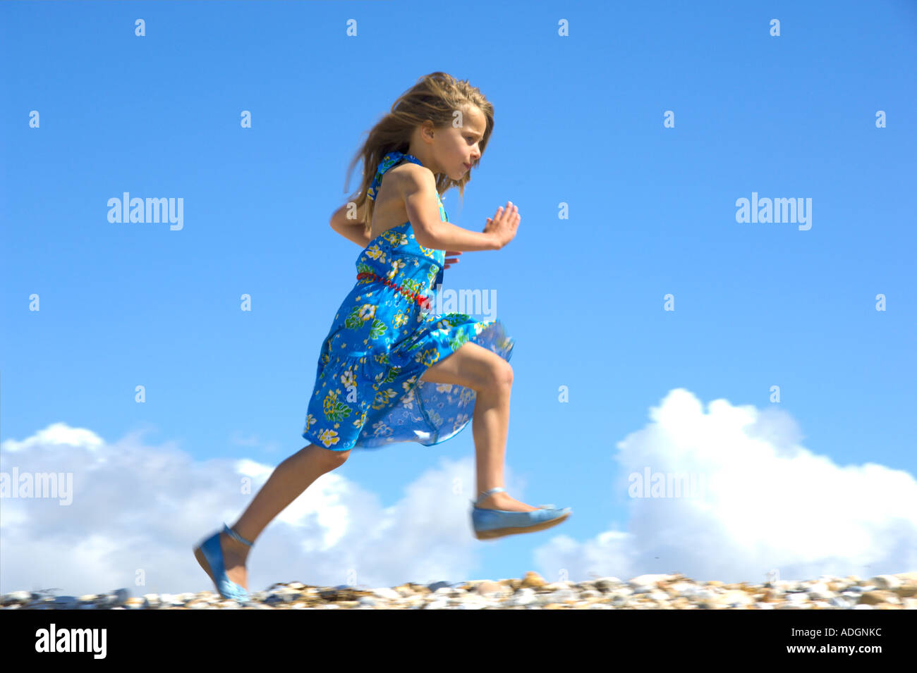 girl running along seaside kicking Stock Photo - Alamy