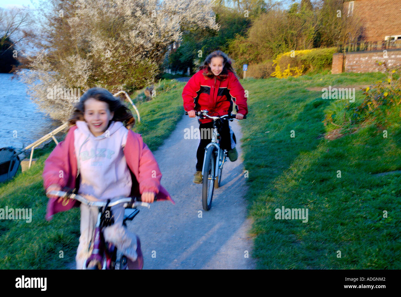 girl children cycling by riverside Stock Photo - Alamy
