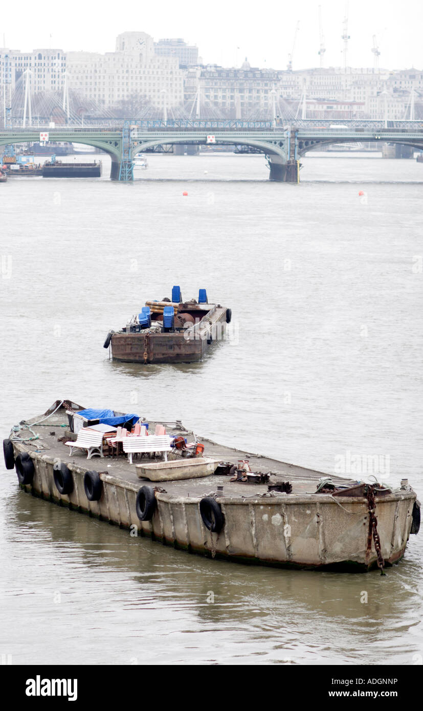 Two derelict concrete barges anchored in the middle of the River Thames ...