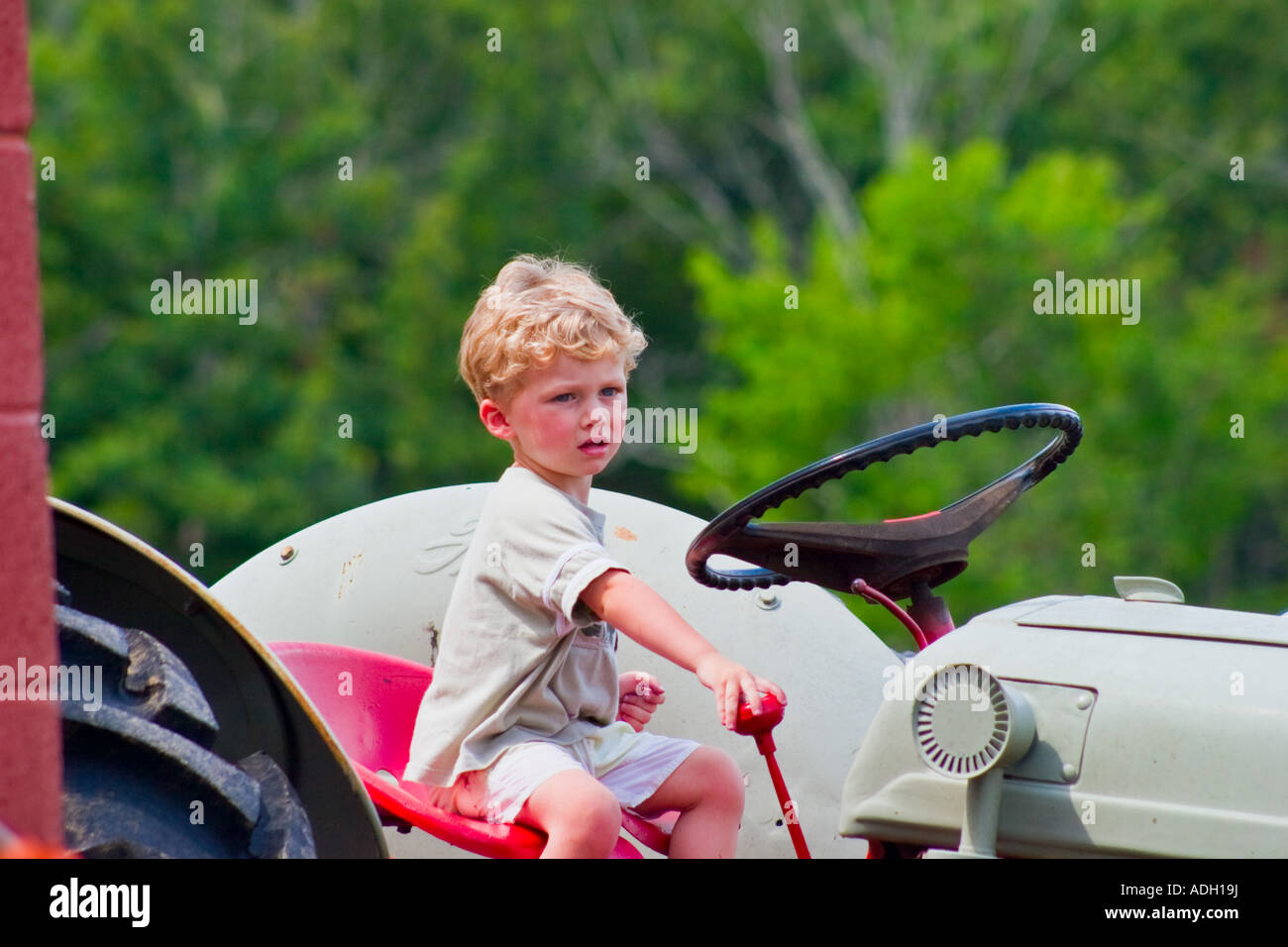 Boy playing on Tractor Stock Photo - Alamy