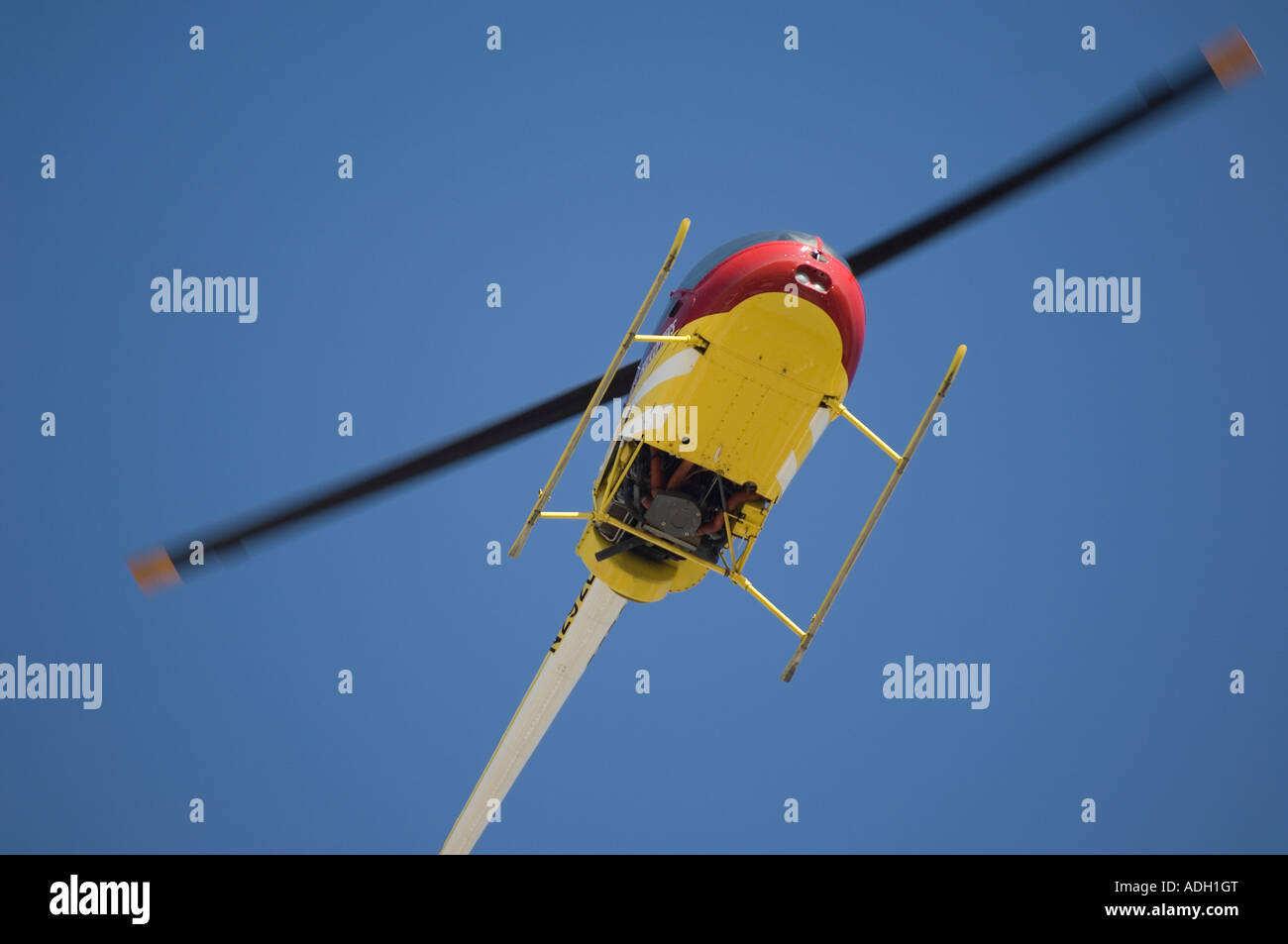 helicopter rotor Robinson R44 red yellow rotor blue sky below above fly ...
