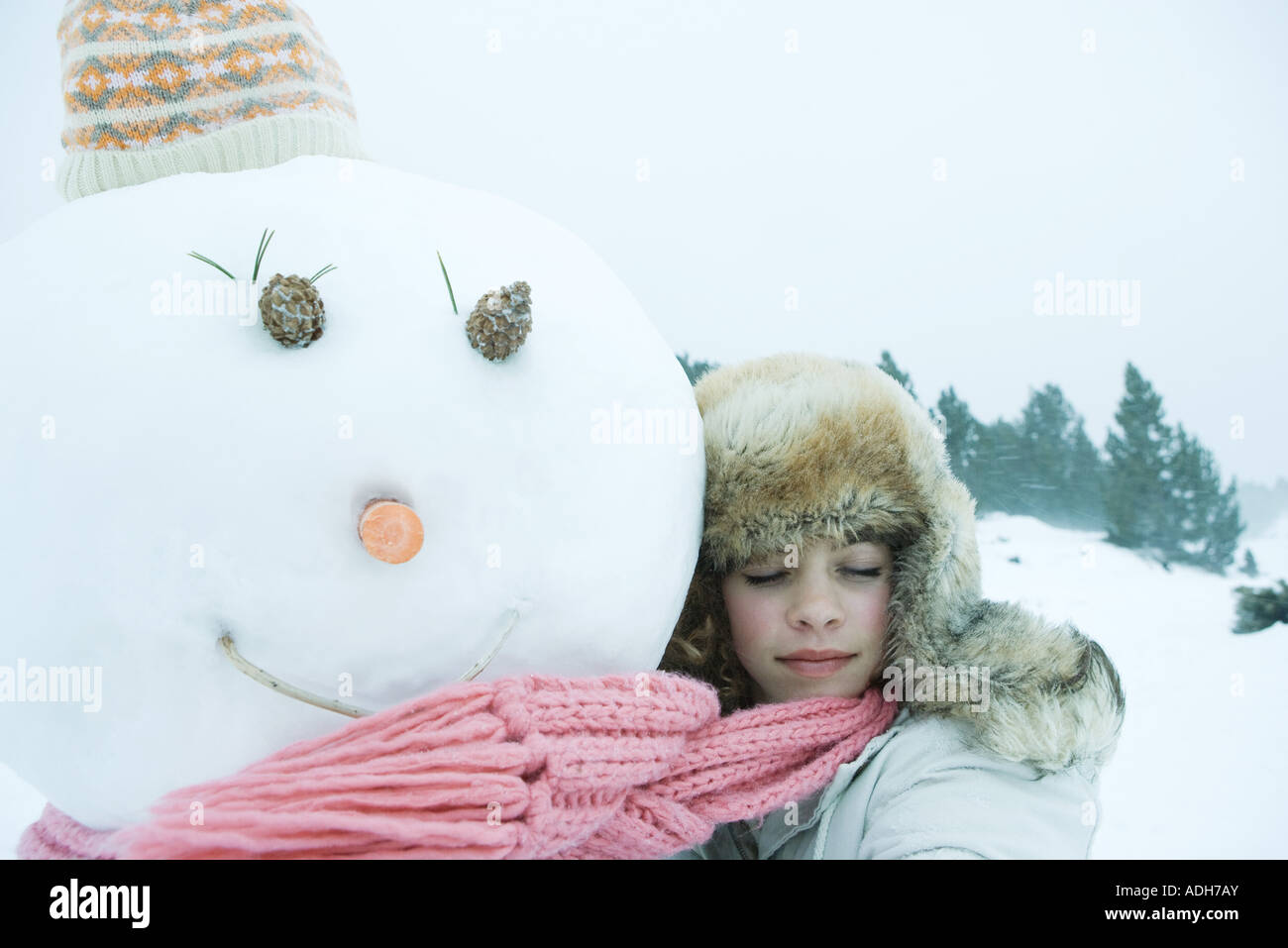 Teen girl hugging snowman Stock Photo - Alamy
