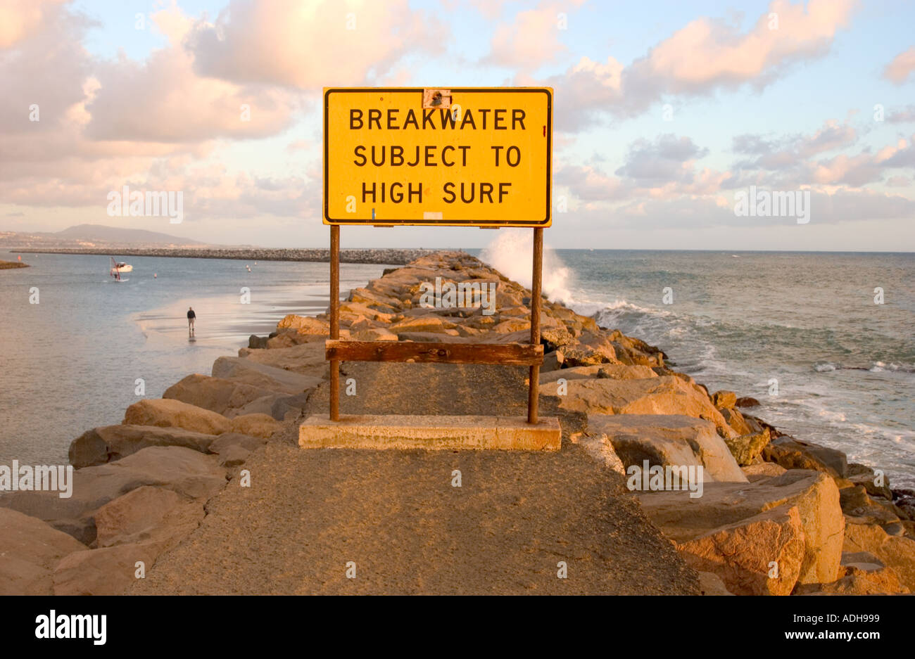 Warning sign by breakwater Stock Photo - Alamy