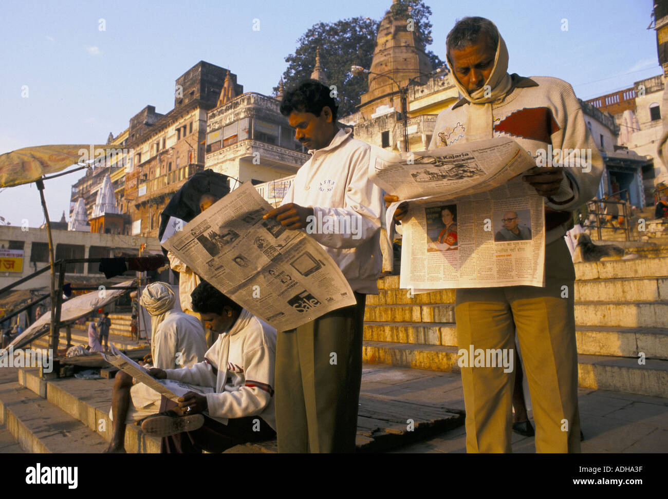 Morning newspapers by the ganges Varanasi India PH Dan White Stock ...