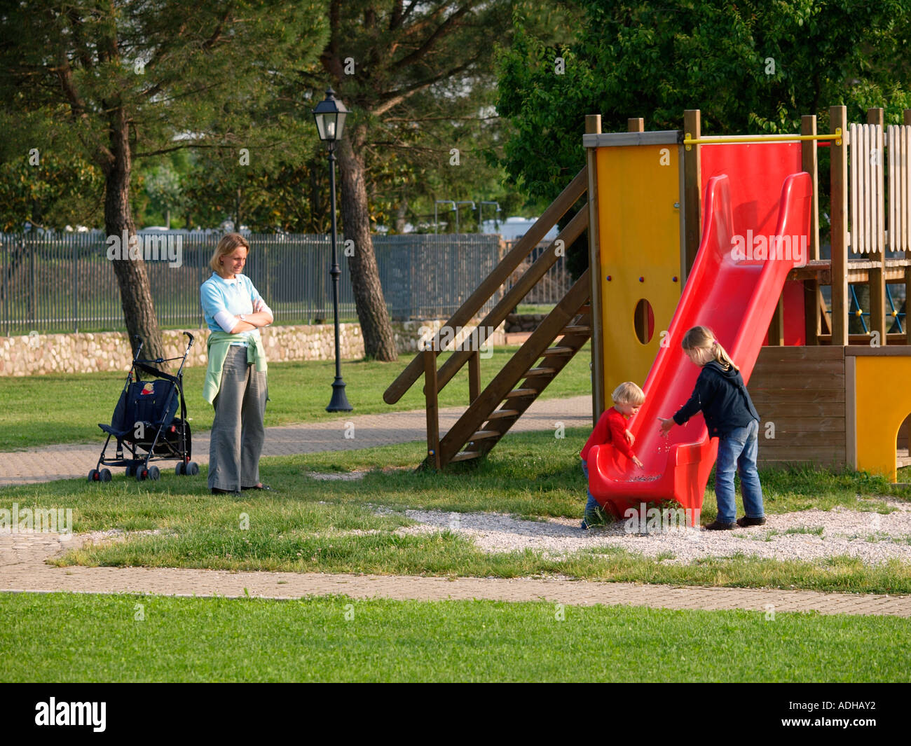 Mother parent watching over supervising her two playing kids age 2 and ...