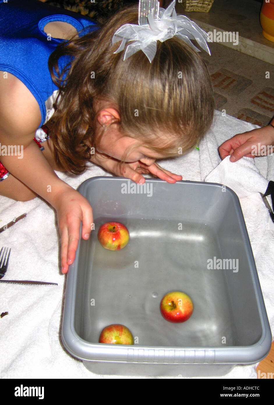 Young girl ducking for apples at Halloween Stock Photo - Alamy