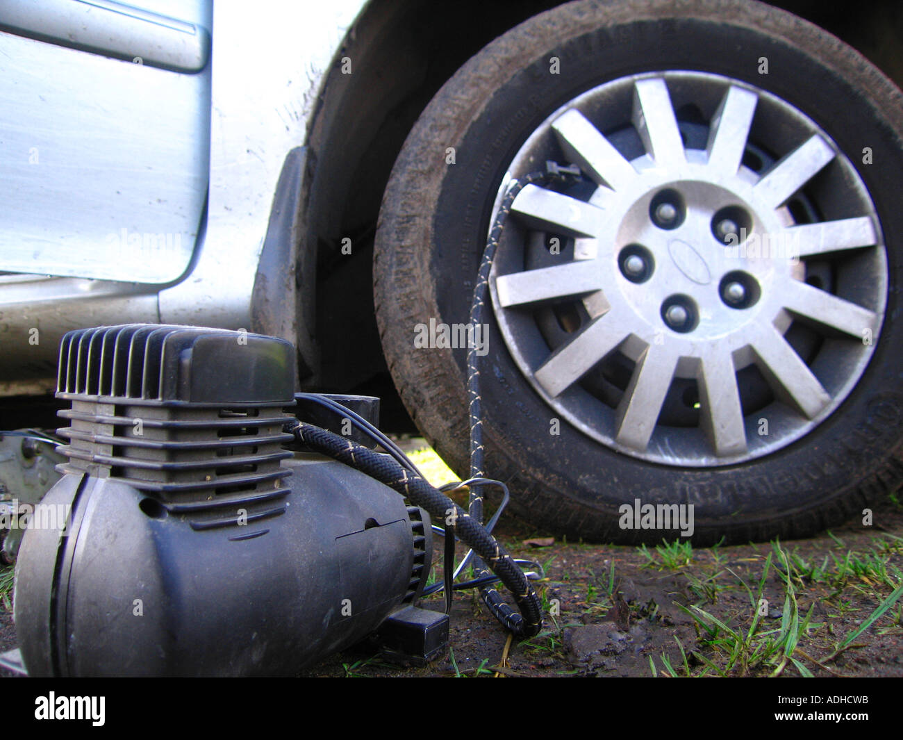 Car tyre being inflated with portable 12 volt compressor Stock Photo ...